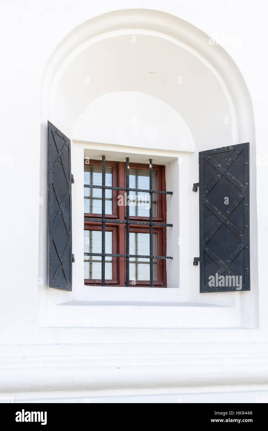 Wooden window with metal hinged shutters decorated with forged grill ...