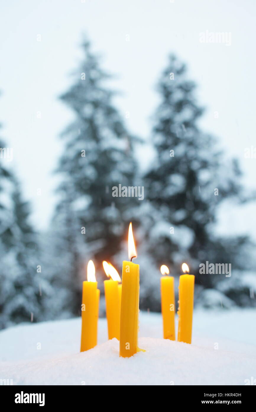 Yellow Candles In Snow Stock Photo - Alamy