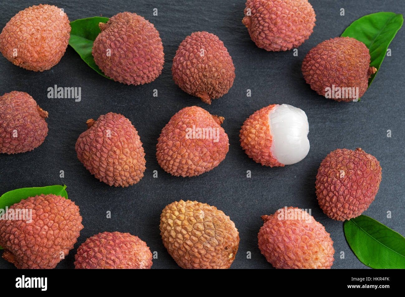 Fresh pile of lychees with leaves on black stone background Stock Photo ...