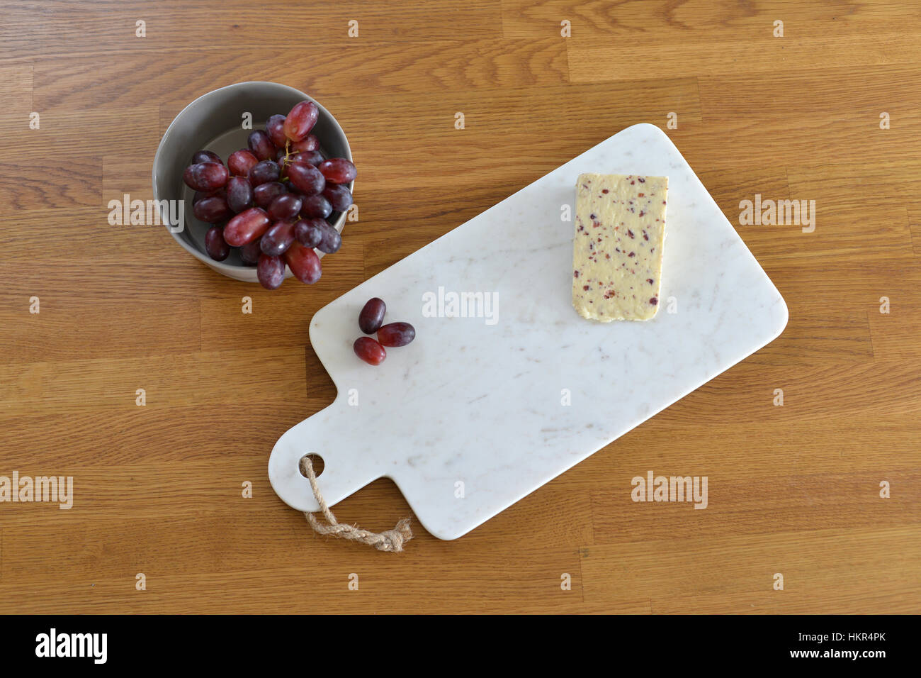 White marble cheese board in a kitchen with cheese and grapes Stock ...