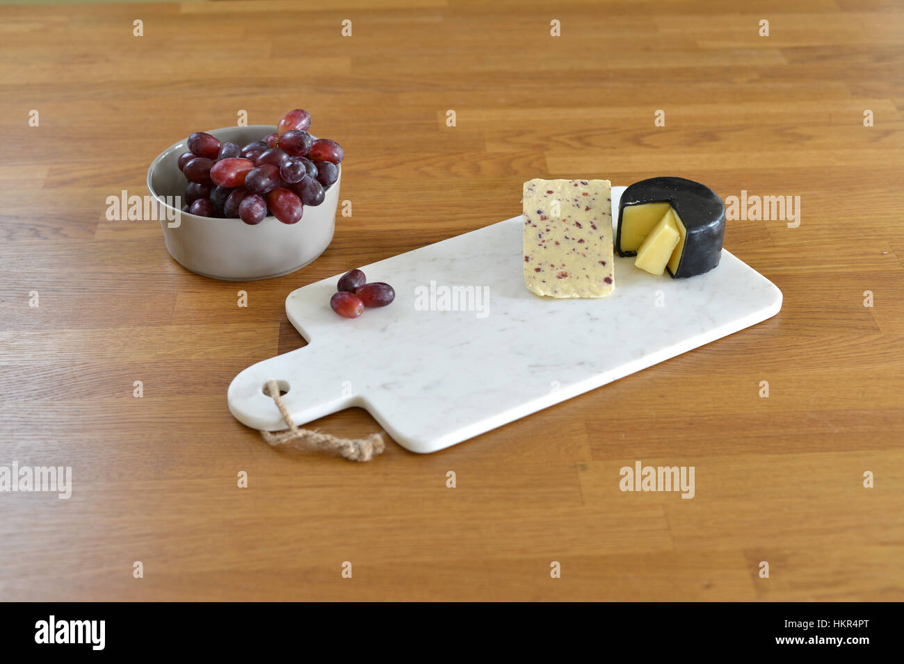 White marble cheese board in a kitchen with cheese and grapes Stock ...