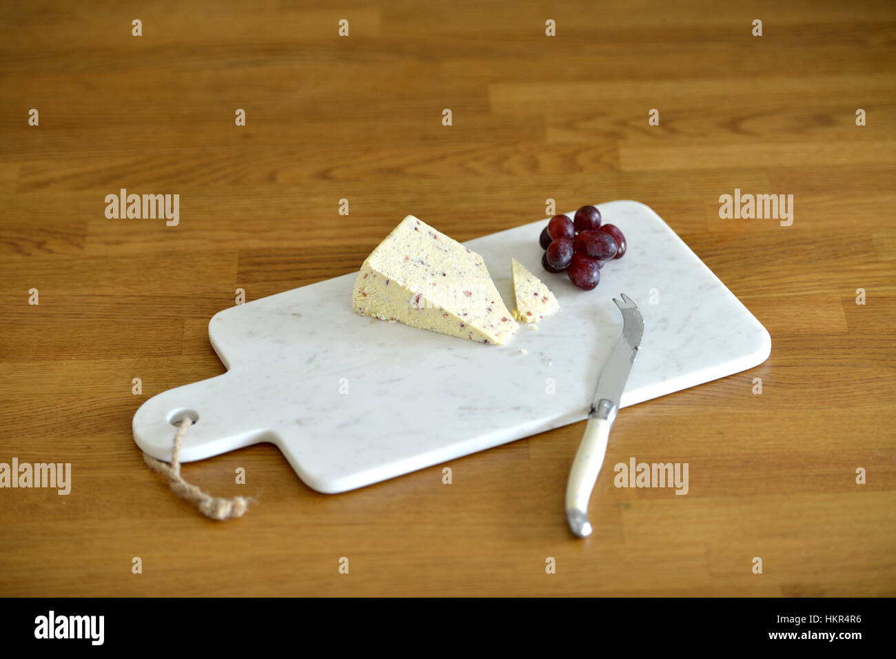 White marble cheese board in a kitchen with cheese and grapes Stock ...