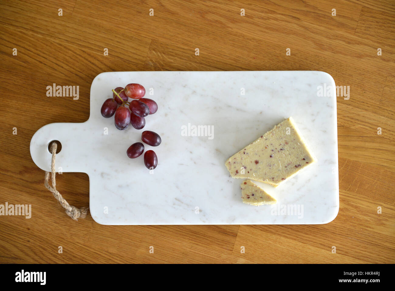White marble cheese board in a kitchen with cheese and grapes Stock ...