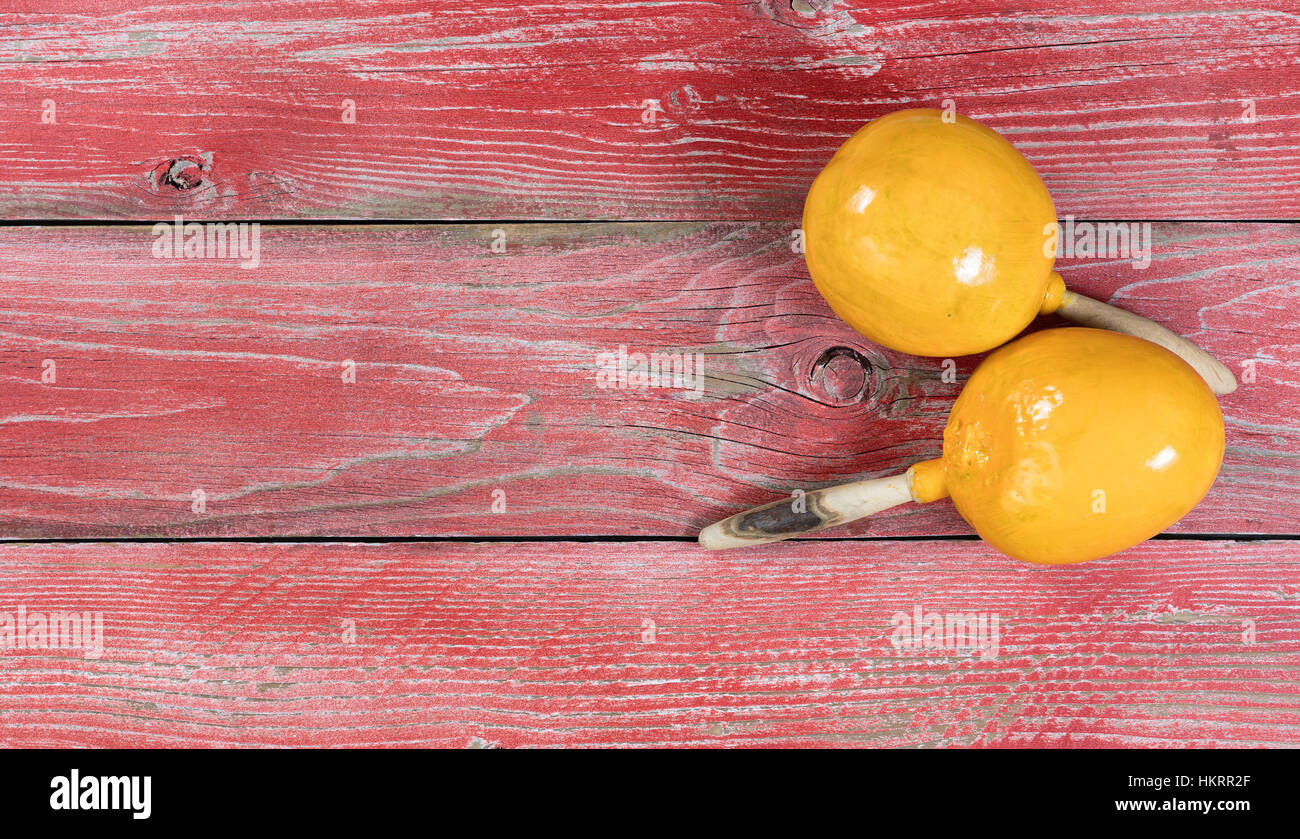 Flat view of yellow maracas on rustic red wooden boards for Cinco de ...