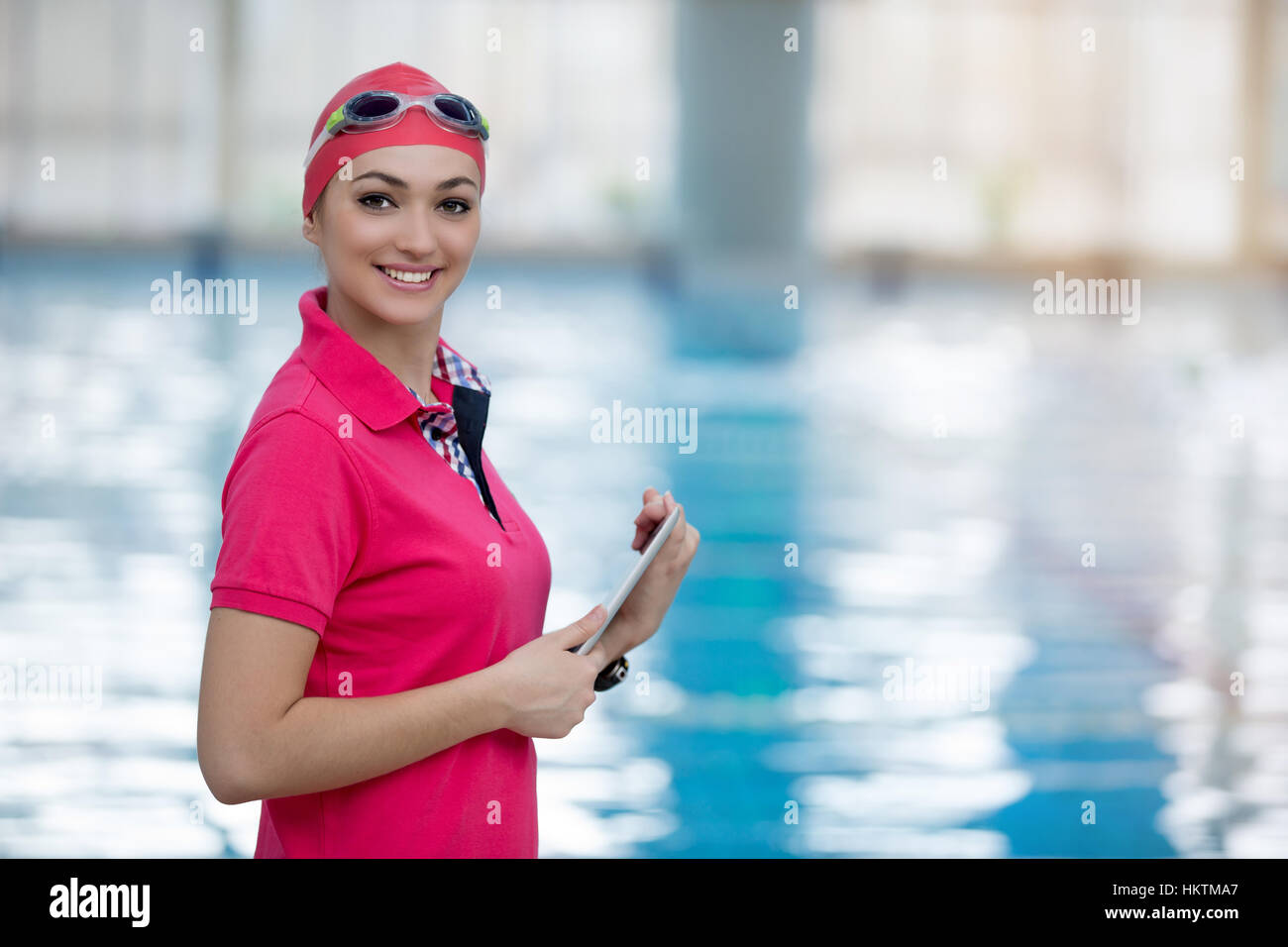 Fit female swimming trainer with tablet at the pool Stock Photo - Alamy