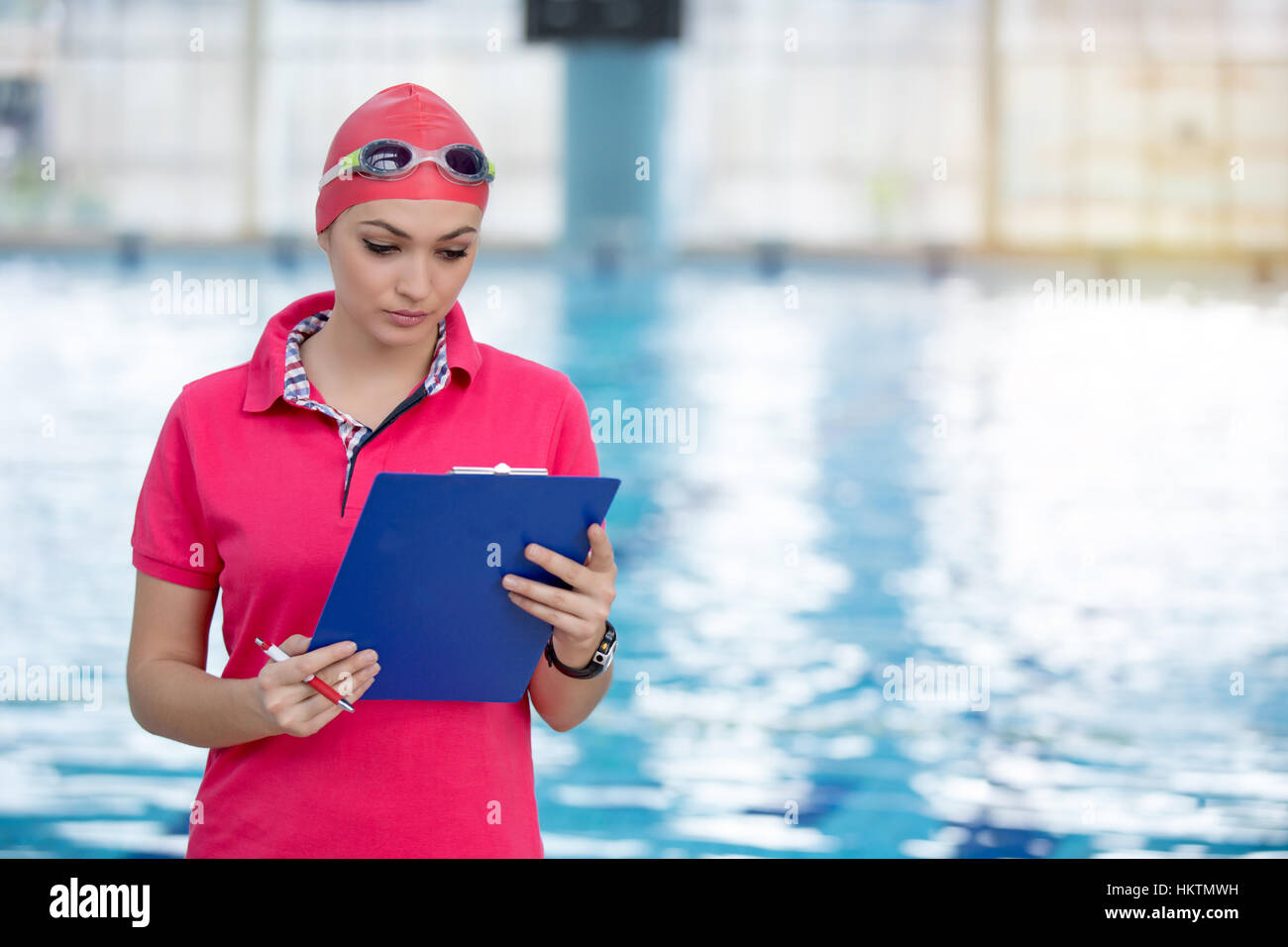 Fit female swimming trainer with tablet at the pool Stock Photo - Alamy