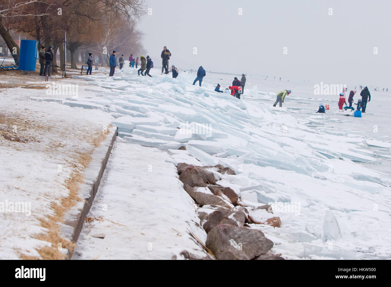 People walking and ice skating on the frozen Balaton Lake at Siofok ...