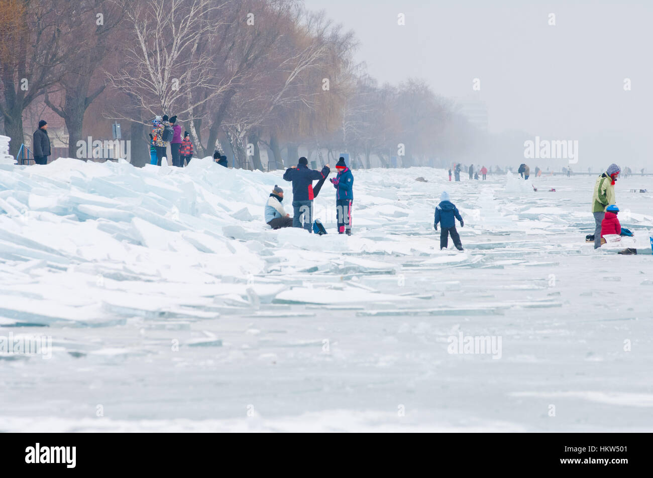 People walking and ice skating on the frozen Balaton Lake at Siofok ...