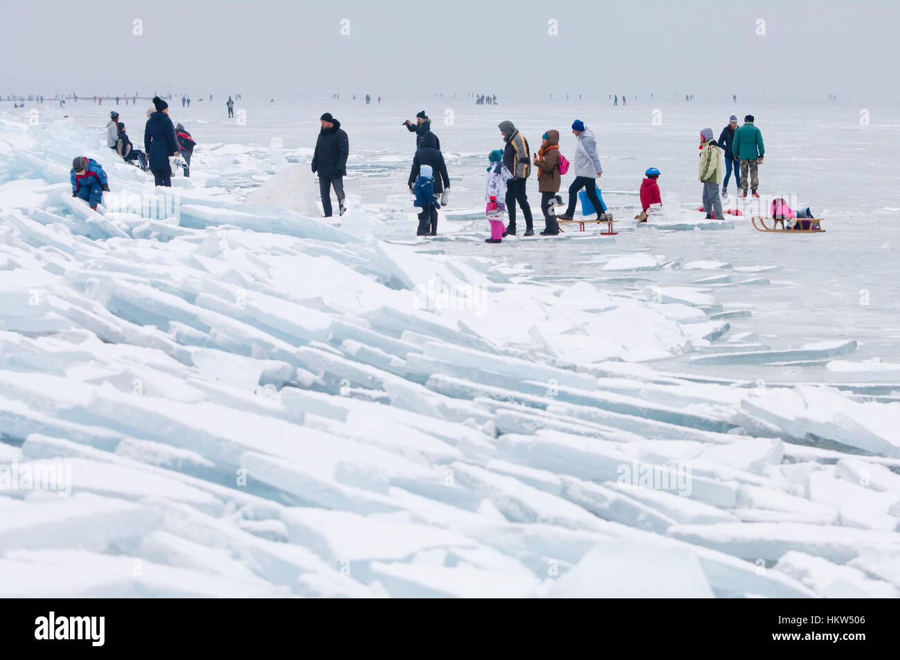 People walking and ice skating on the frozen Balaton Lake at Siofok ...
