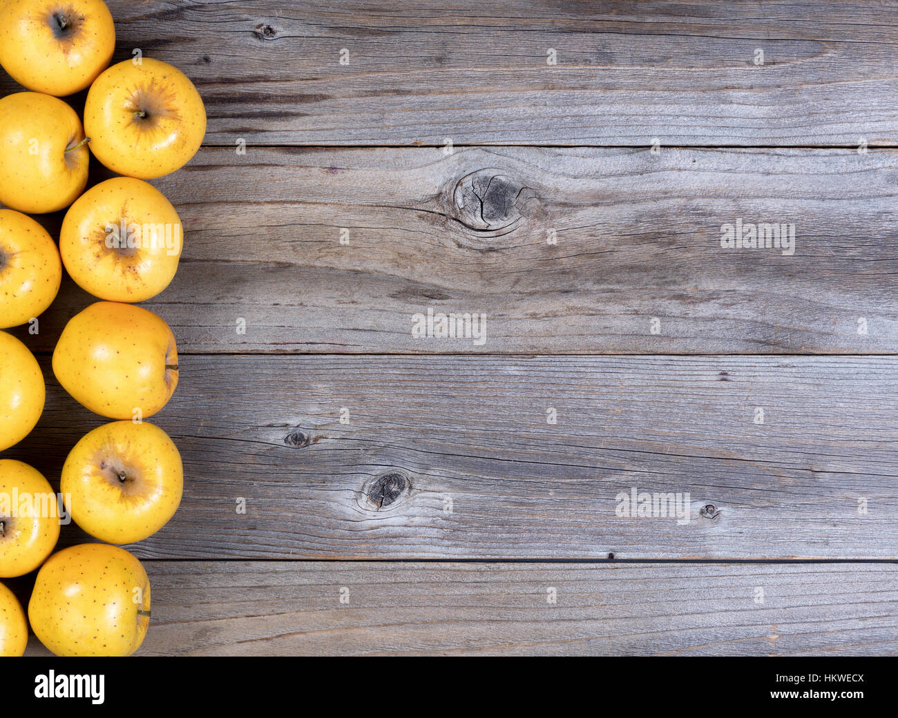 Golden apples, on left hand side, on rustic wooden boards Stock Photo ...