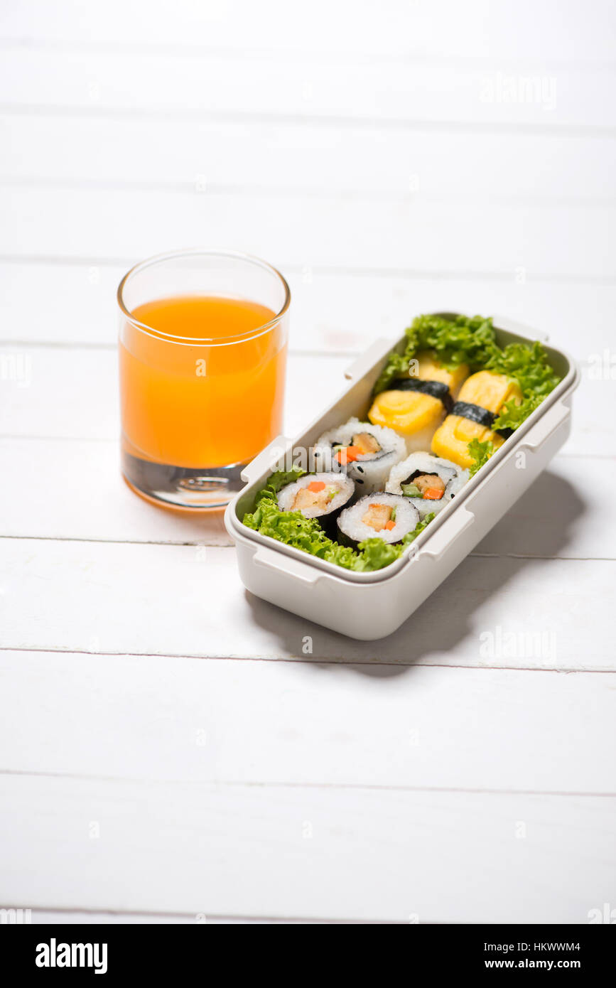 Orange juice and bento box with different food, fresh veggies and ...