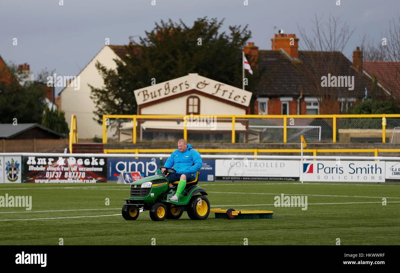 Sutton United Goalkeeper Wayne Shaw attends to the artificial pitch ...