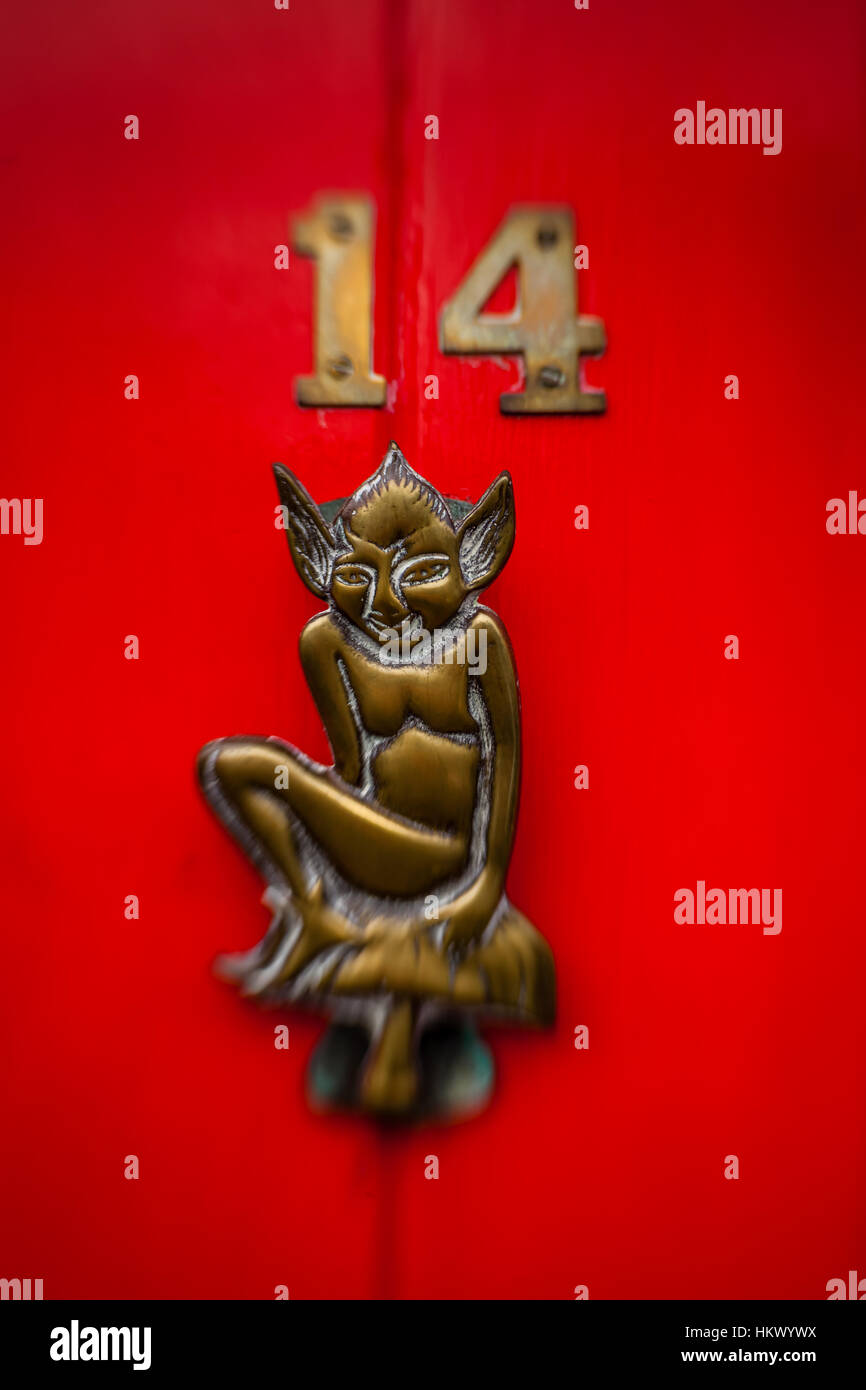 Bronze devilish figure on the red doors Stock Photo - Alamy