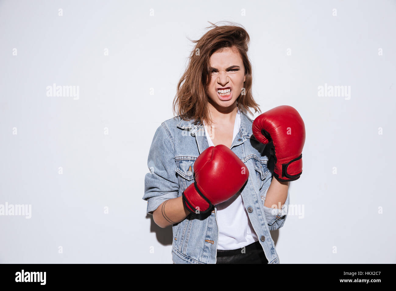 Picture of angry lady boxer dressed in jeans jacket and gloves standing ...