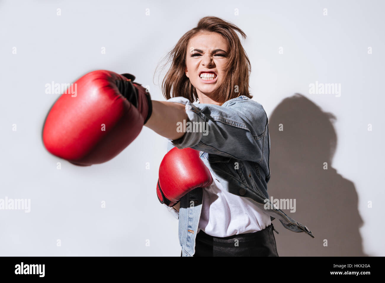 Picture of emotional woman boxer dressed in jeans jacket and gloves ...