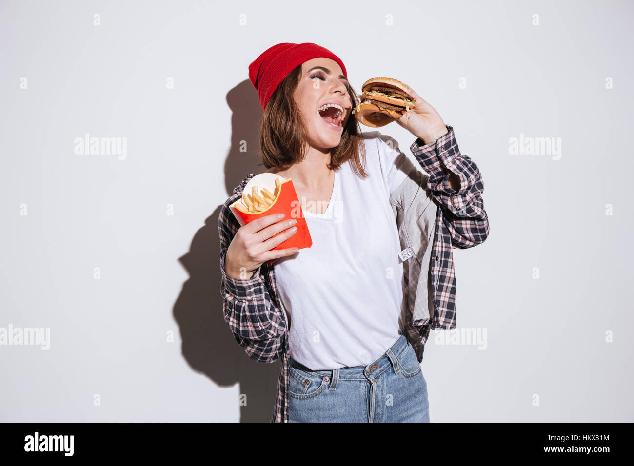 Image of hungry lady dressed in shirt in a cage print wearing hat ...