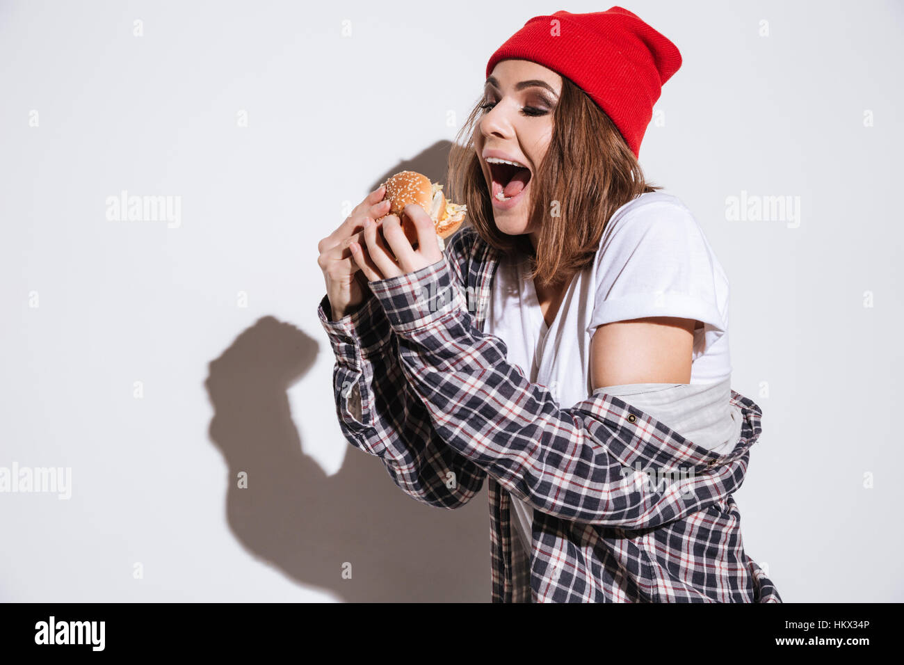Image of hungry lady dressed in shirt in a cage print wearing hat ...
