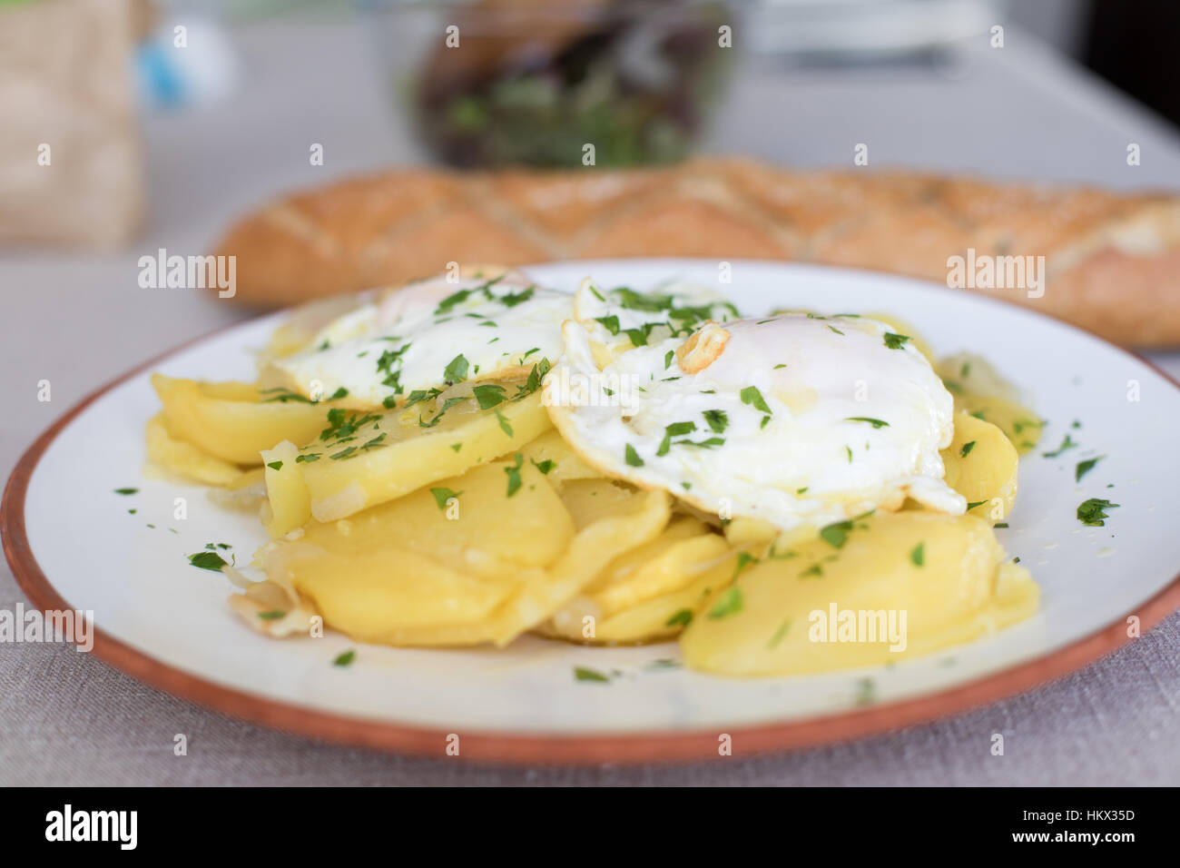 white circular dish with typical Spanish food, sliced fried potatoes ...