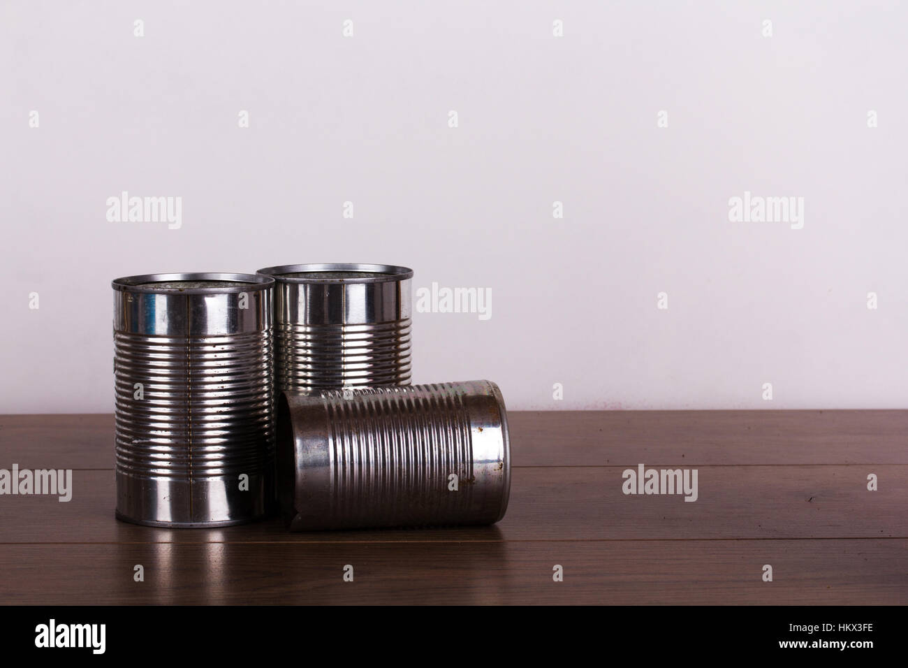 Battered tin cans on a rustic wooden background Stock Photo - Alamy