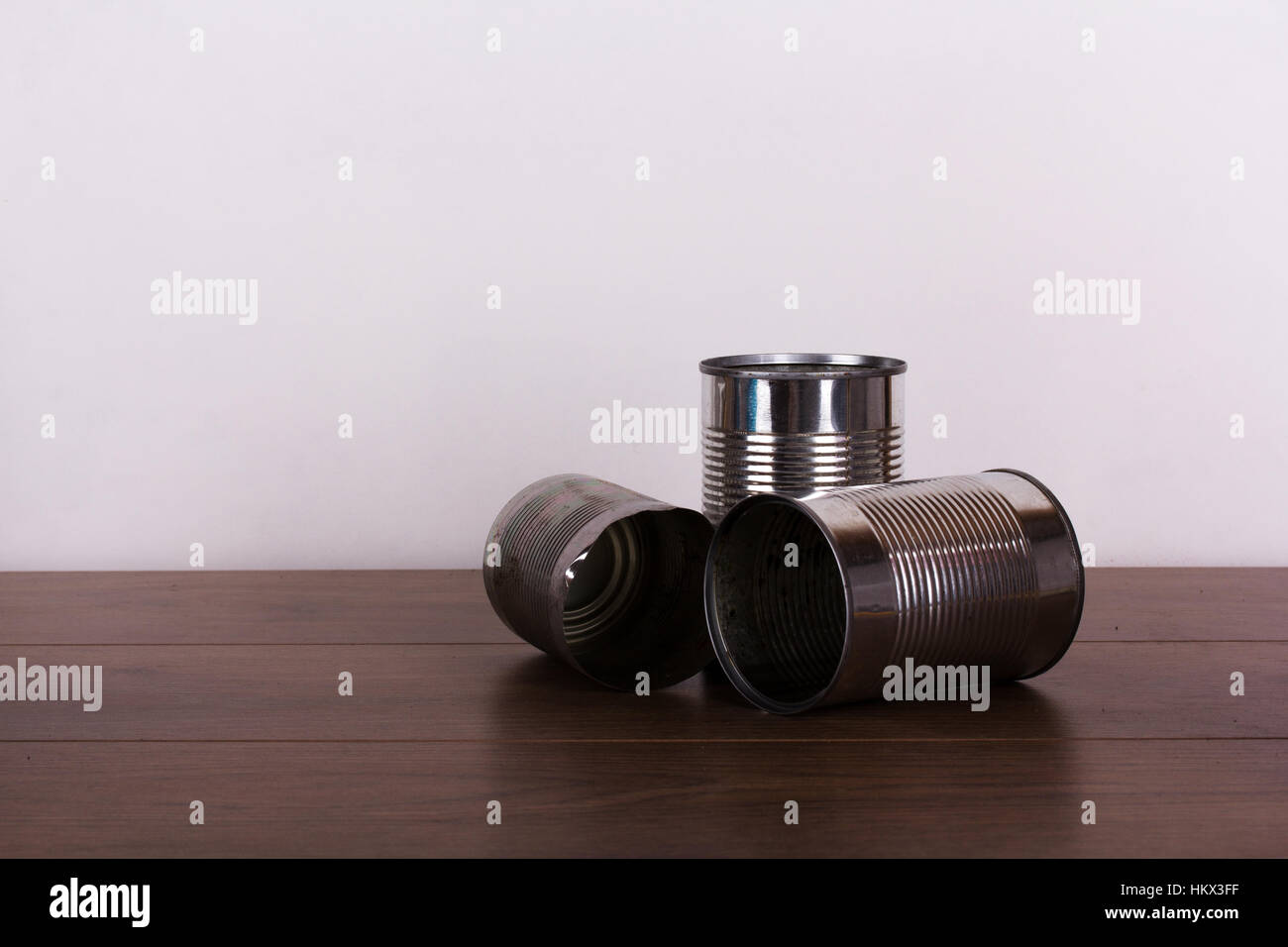 Battered tin cans on a rustic wooden background Stock Photo - Alamy