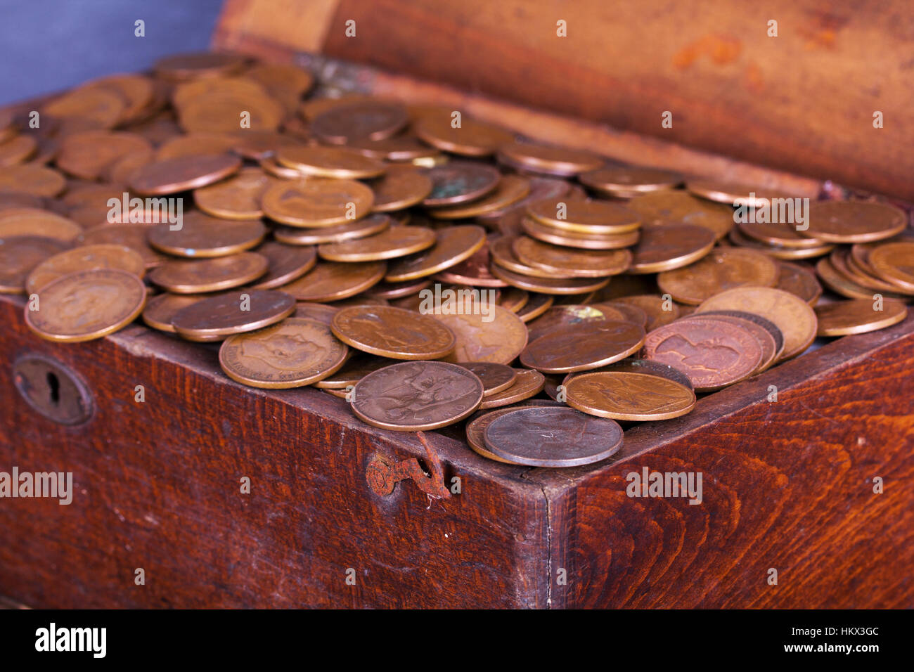 Old wooden chest filled with old copper coins Stock Photo - Alamy