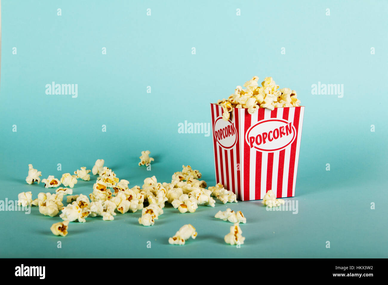 Bucket of popcorn against a blue background Stock Photo - Alamy