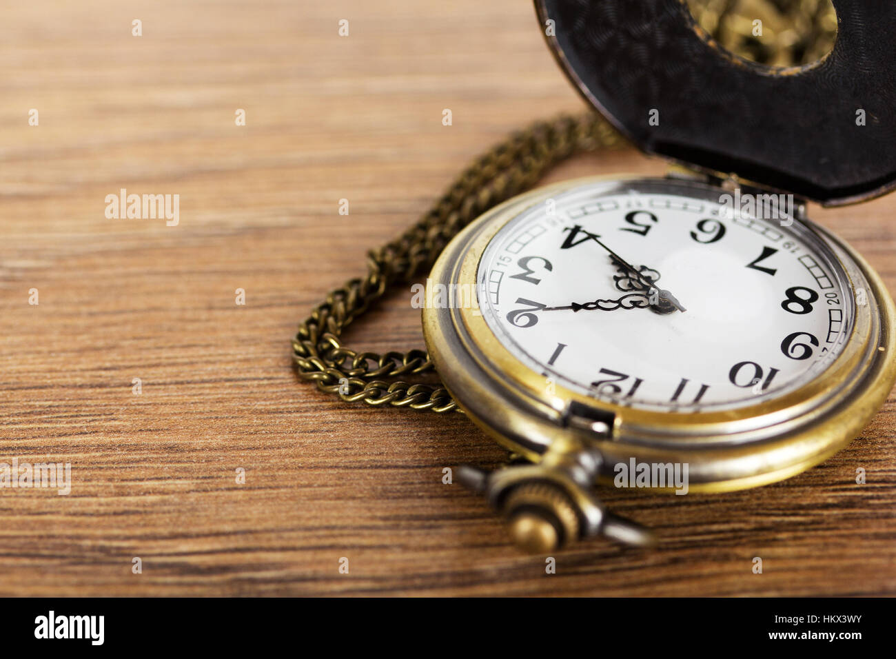 Pocket watch against a rustic wooden background Stock Photo - Alamy