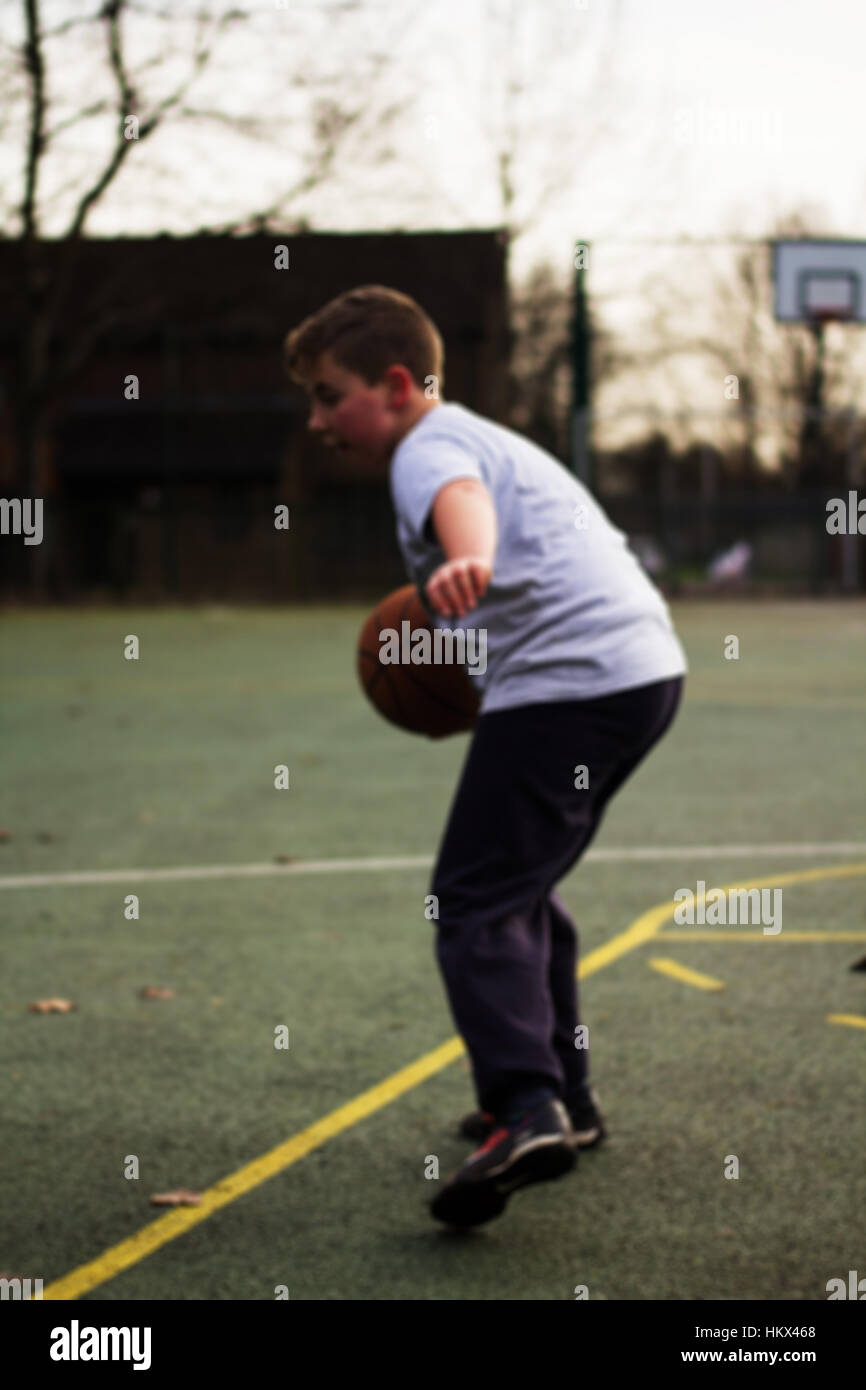 Child practicing playing basketball in a local park Stock Photo - Alamy