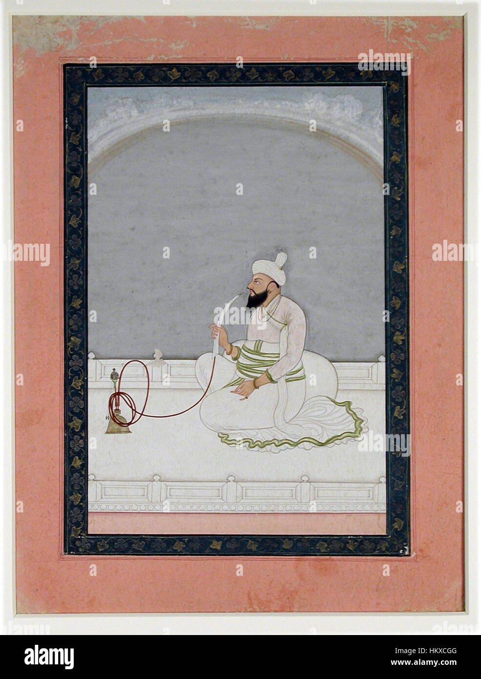 This image depicts Brij Raj Dev of Jammu smoking a hookah, capturing a moment of leisure and ...