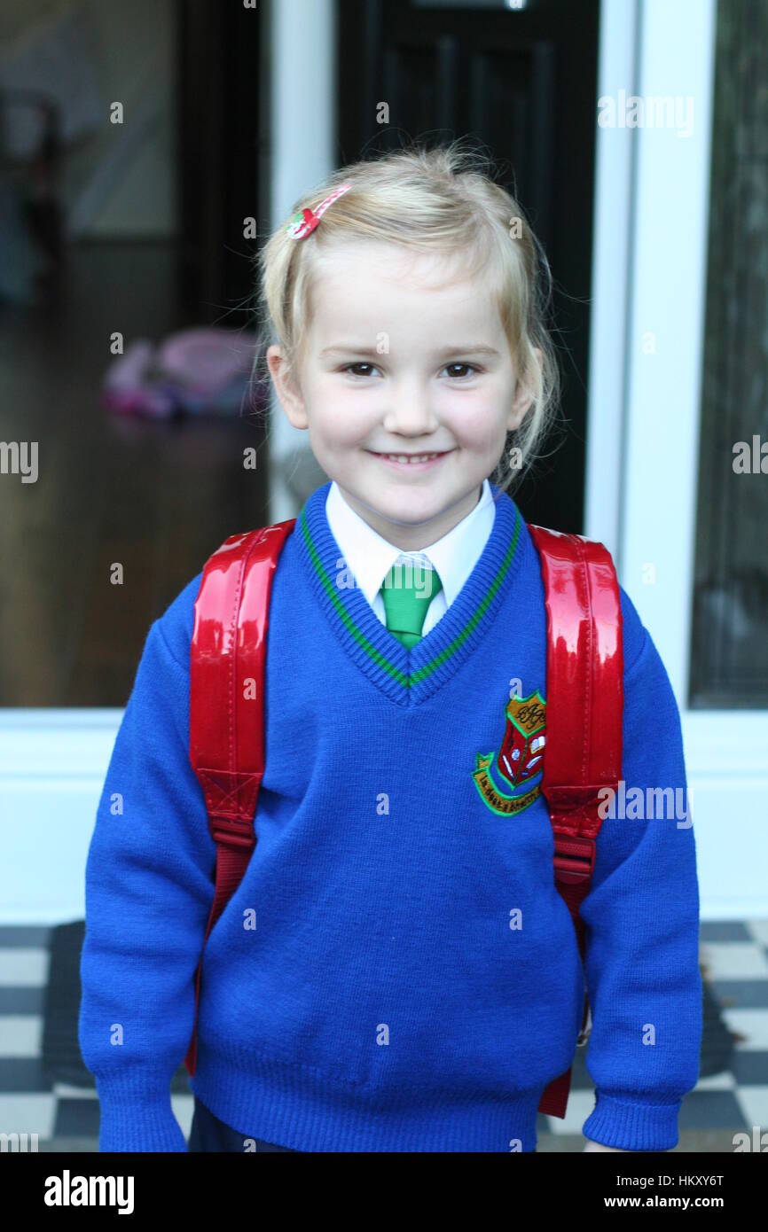 Little blonde girl child wearing her school uniform on her first day of ...