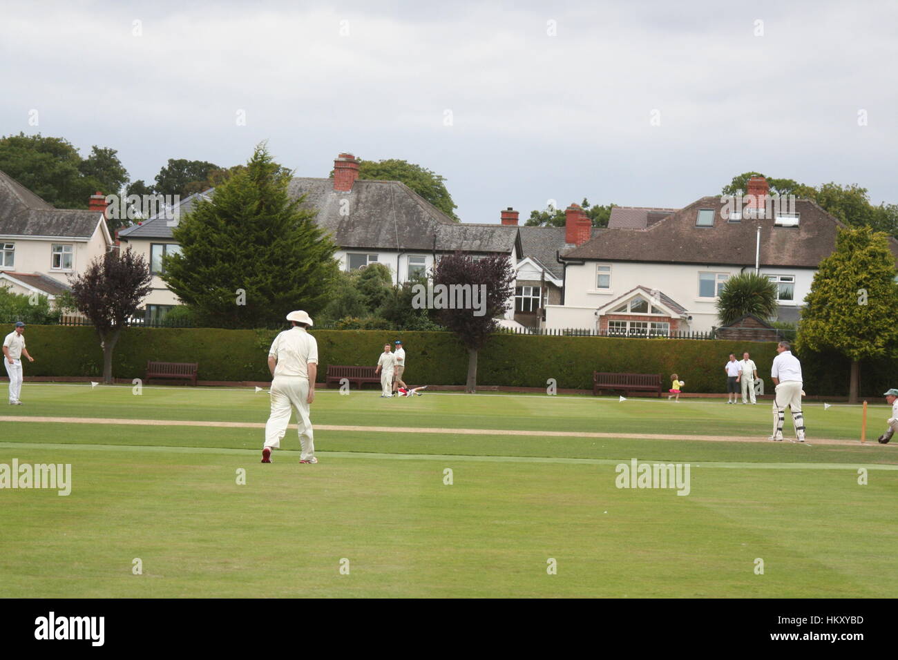 Men, batsmen, people wearing white playing cricket on a freshly cut ...