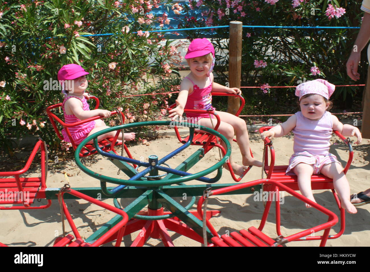 little girls sitting on a merry go round at a playground, baby girls ...
