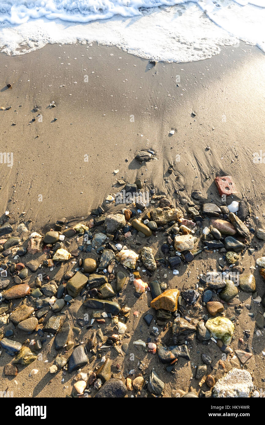 Close-up of mediterranean beach, with pebbles, and small waves, tide ...