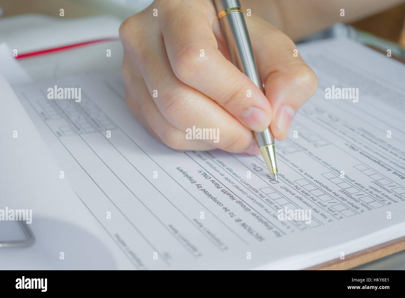 Hand with pen over application form Stock Photo - Alamy
