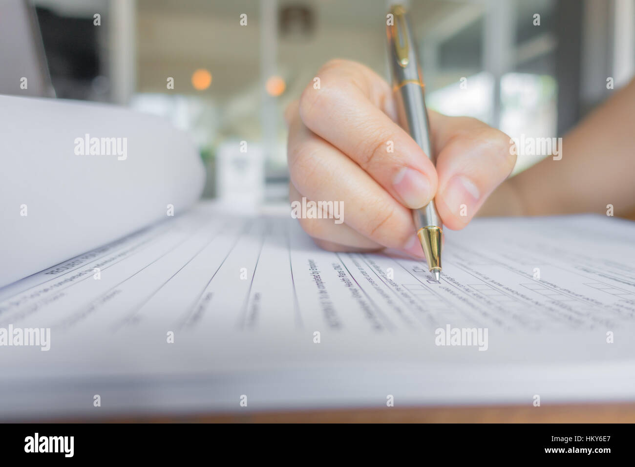 Hand with pen over application form Stock Photo - Alamy