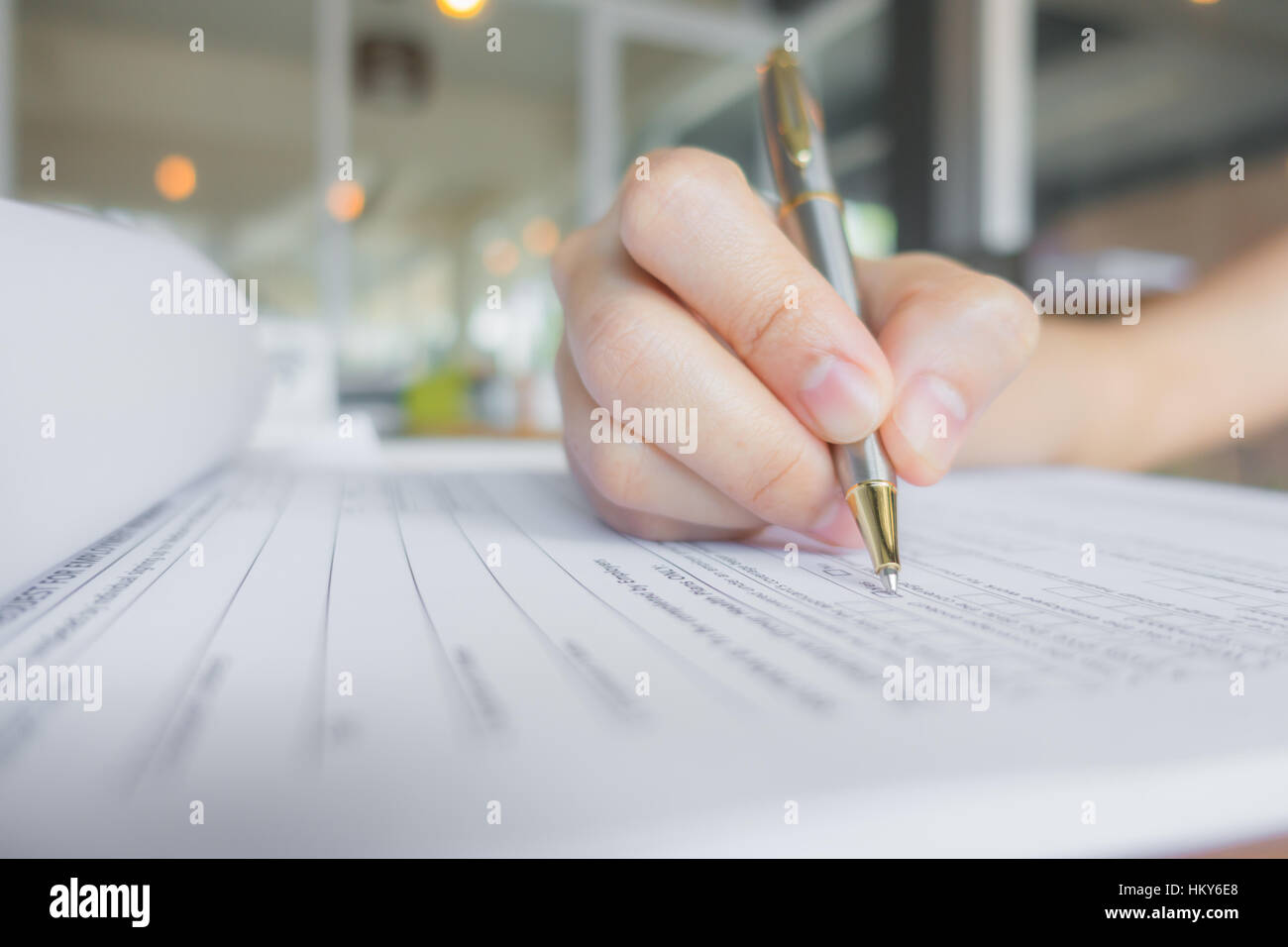 Hand with pen over application form Stock Photo - Alamy