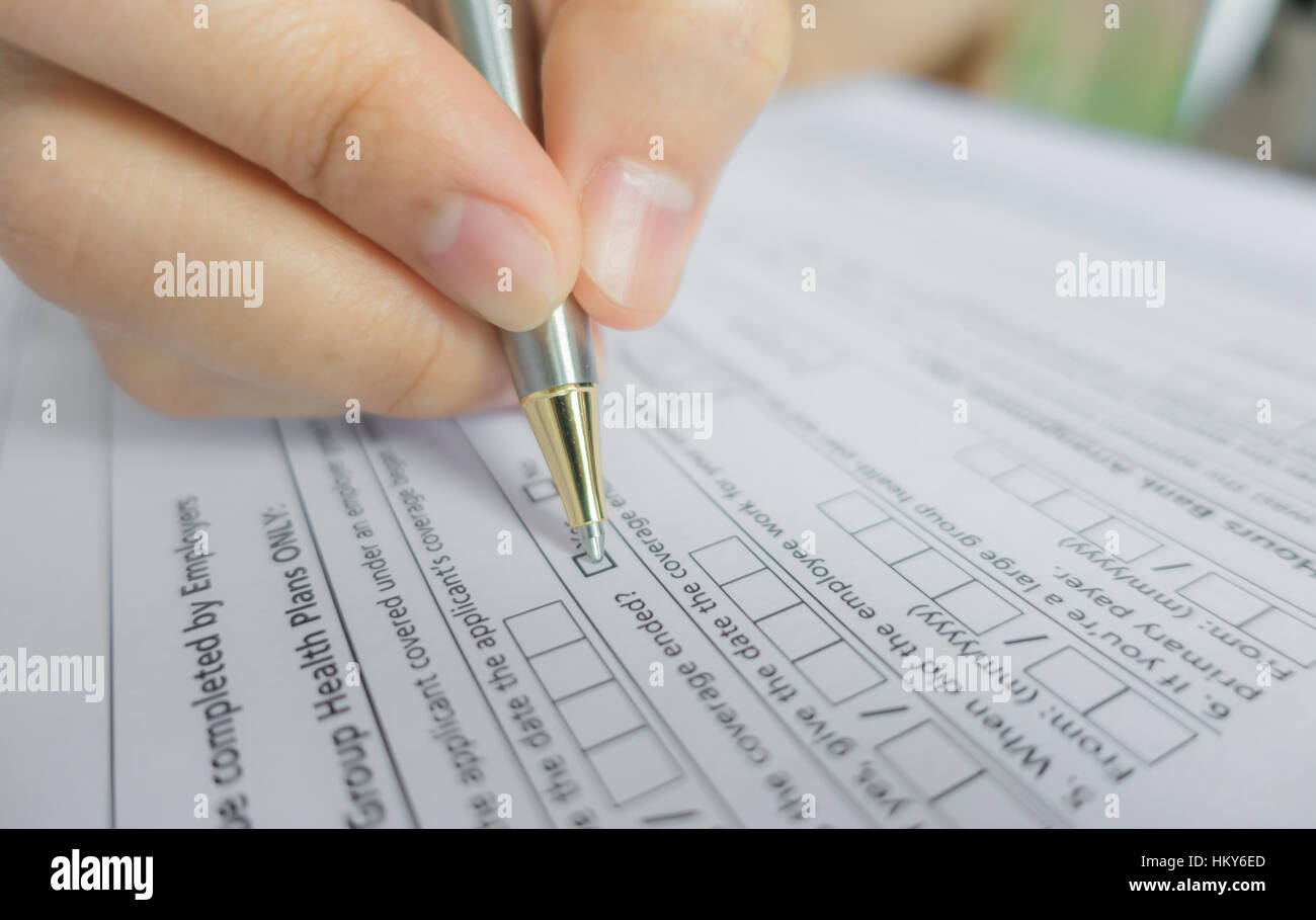 Hand with pen over application form Stock Photo - Alamy