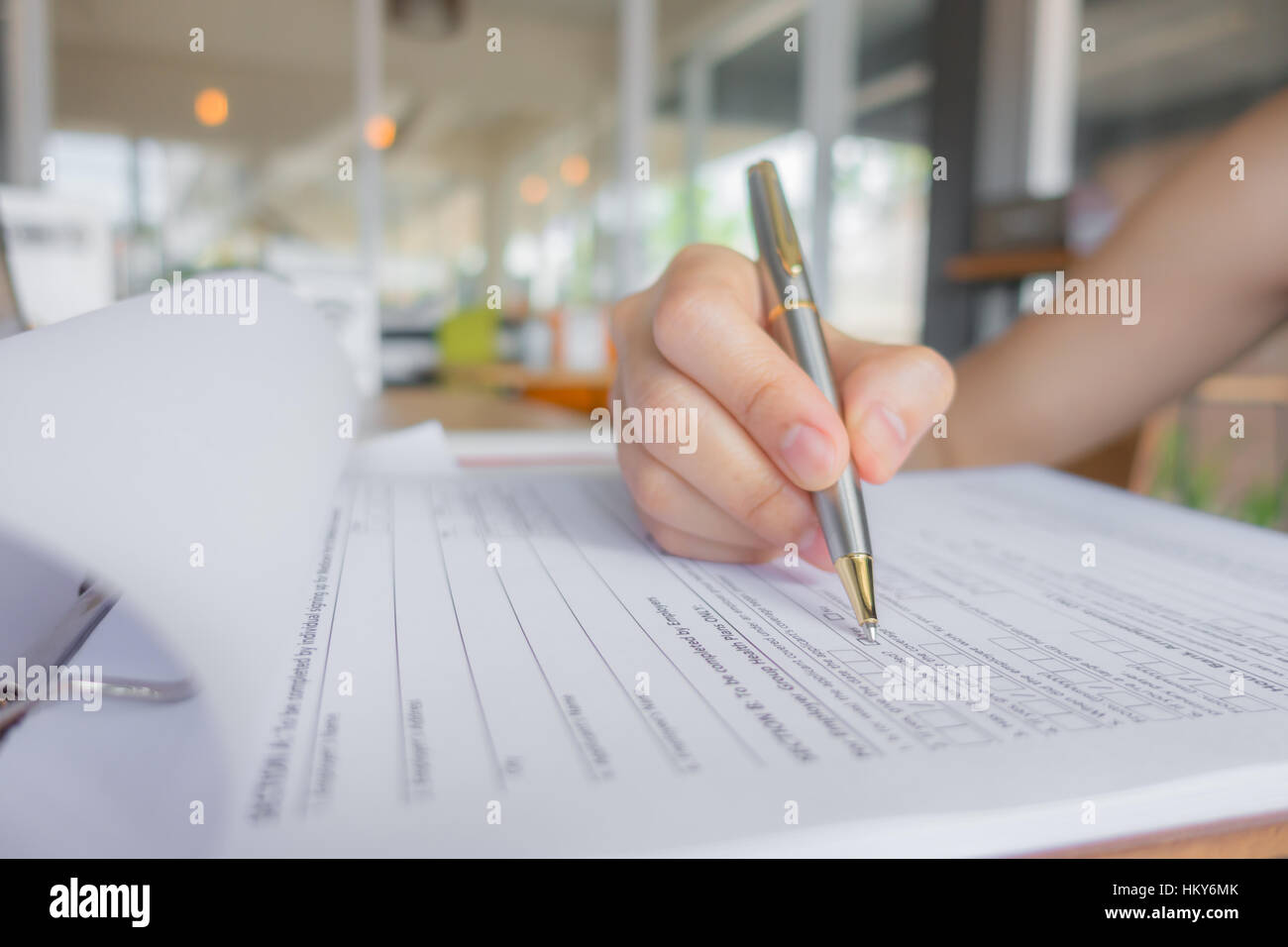 Hand with pen over application form Stock Photo - Alamy