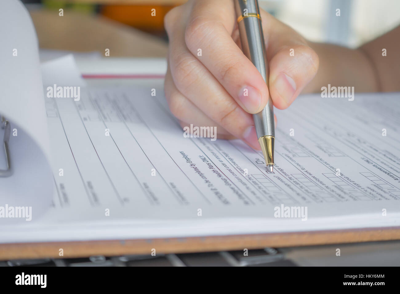 Hand with pen over application form Stock Photo - Alamy