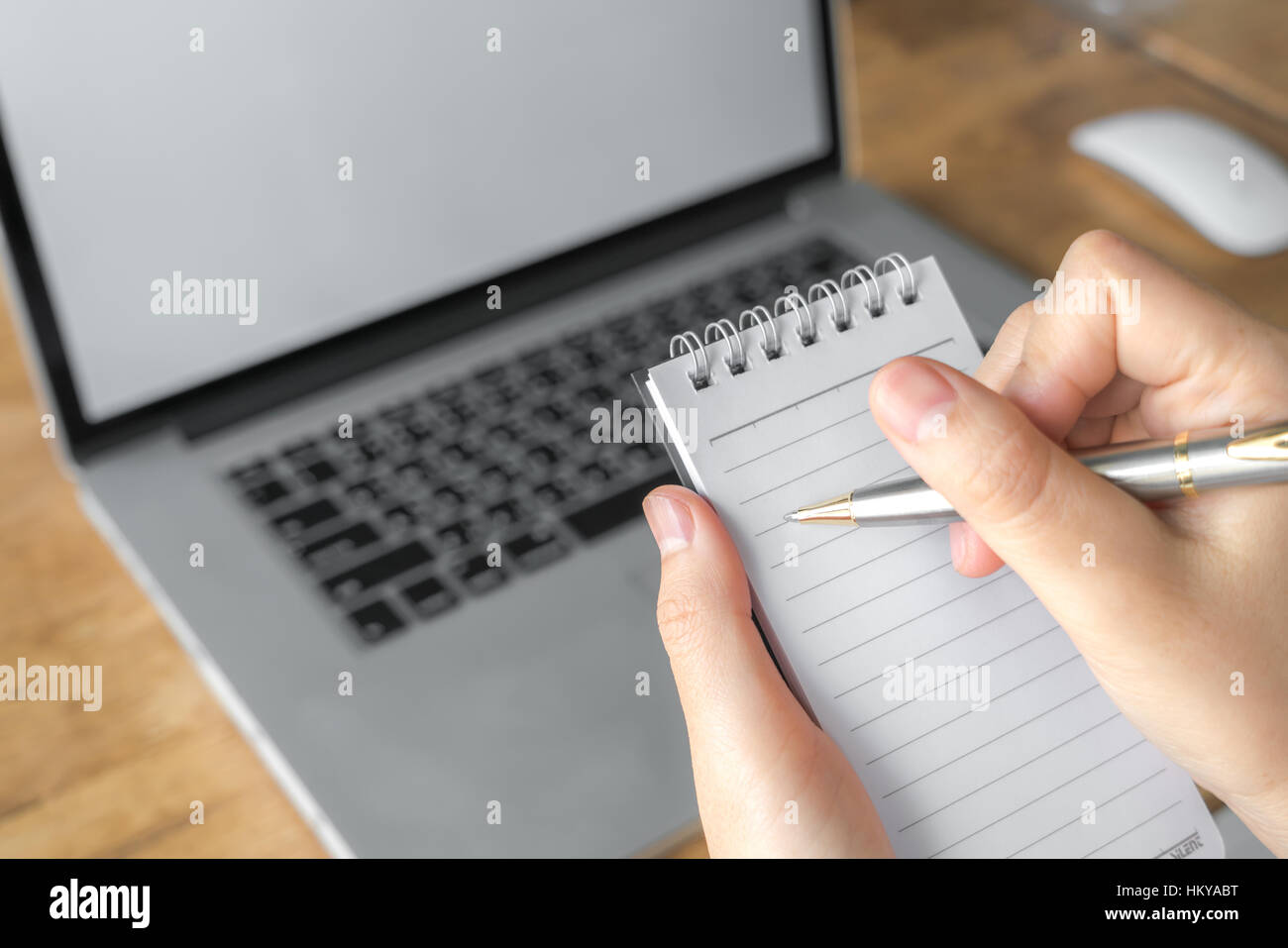 Woman hand using a pencil noting over laptop Stock Photo - Alamy