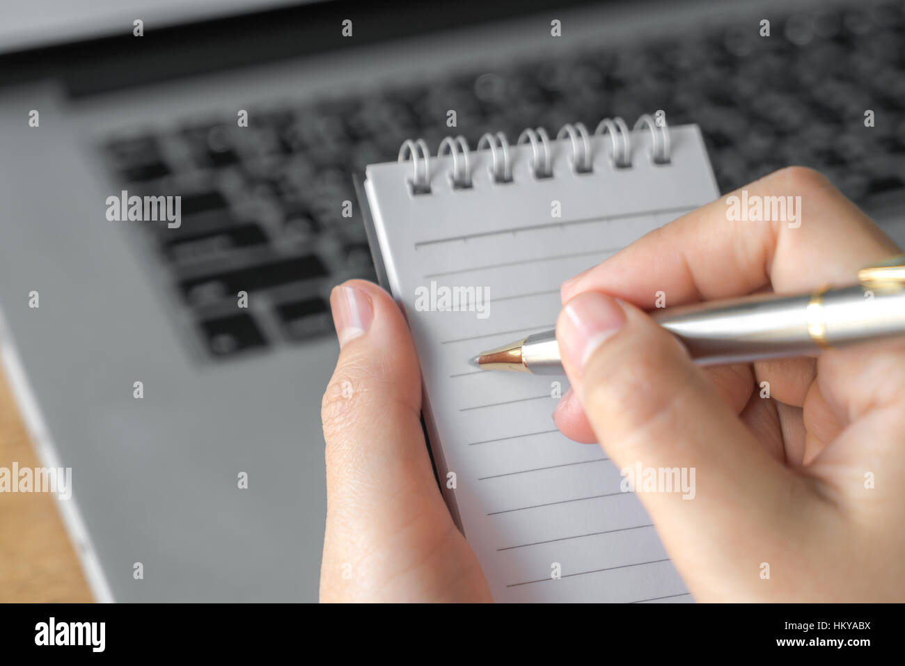 Woman hand using a pencil noting over laptop Stock Photo - Alamy