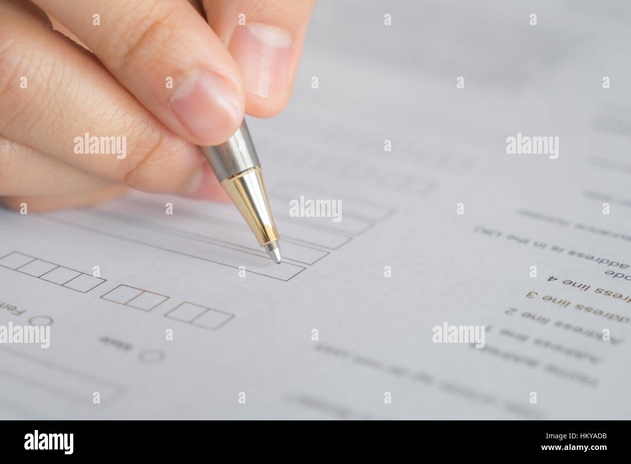 Hand with pen over application form Stock Photo - Alamy