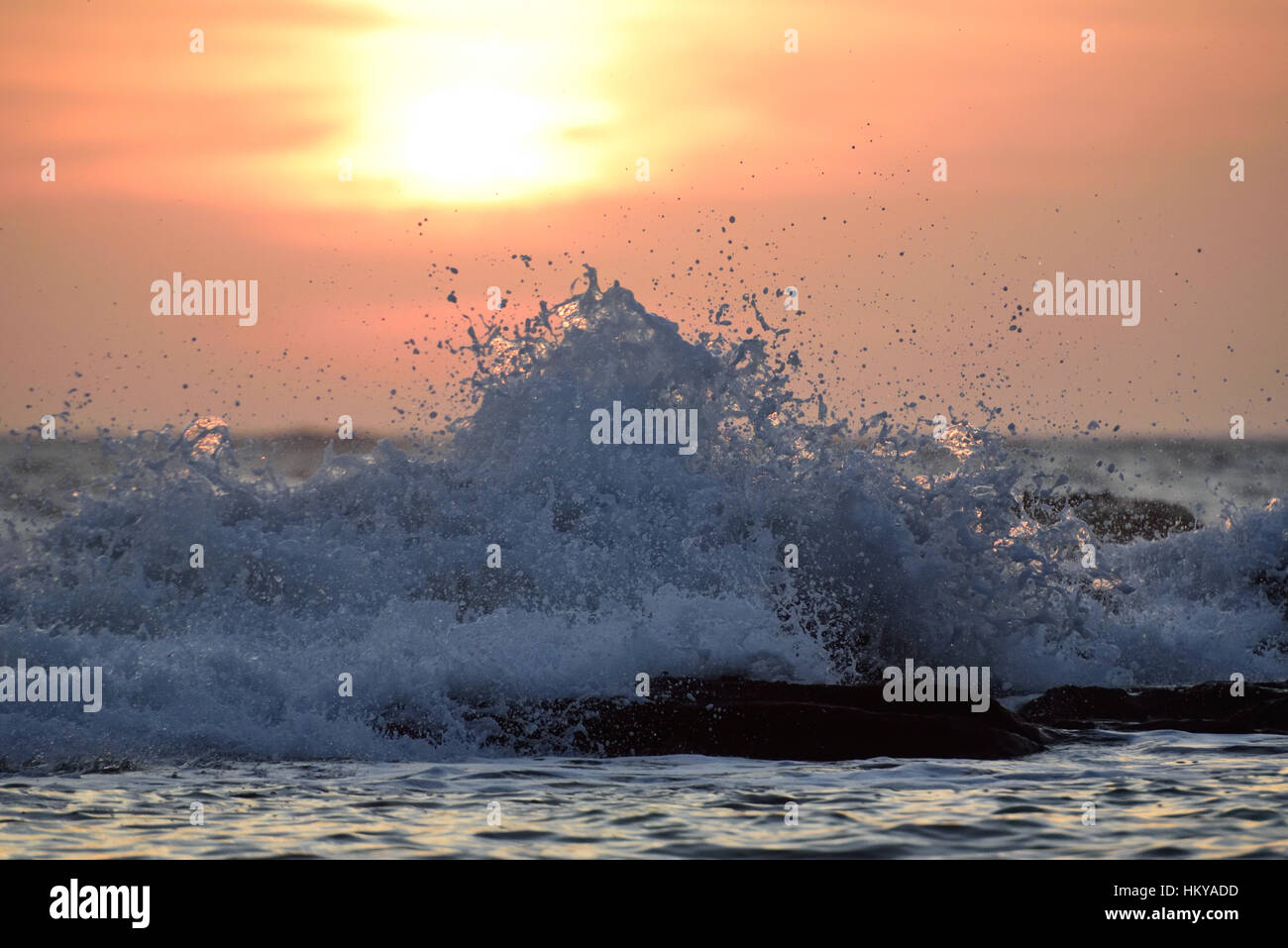 close up of sea water splash on rocks sunset background Stock Photo - Alamy