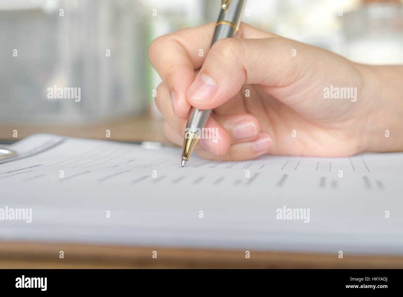 Hand with pen over application form Stock Photo - Alamy