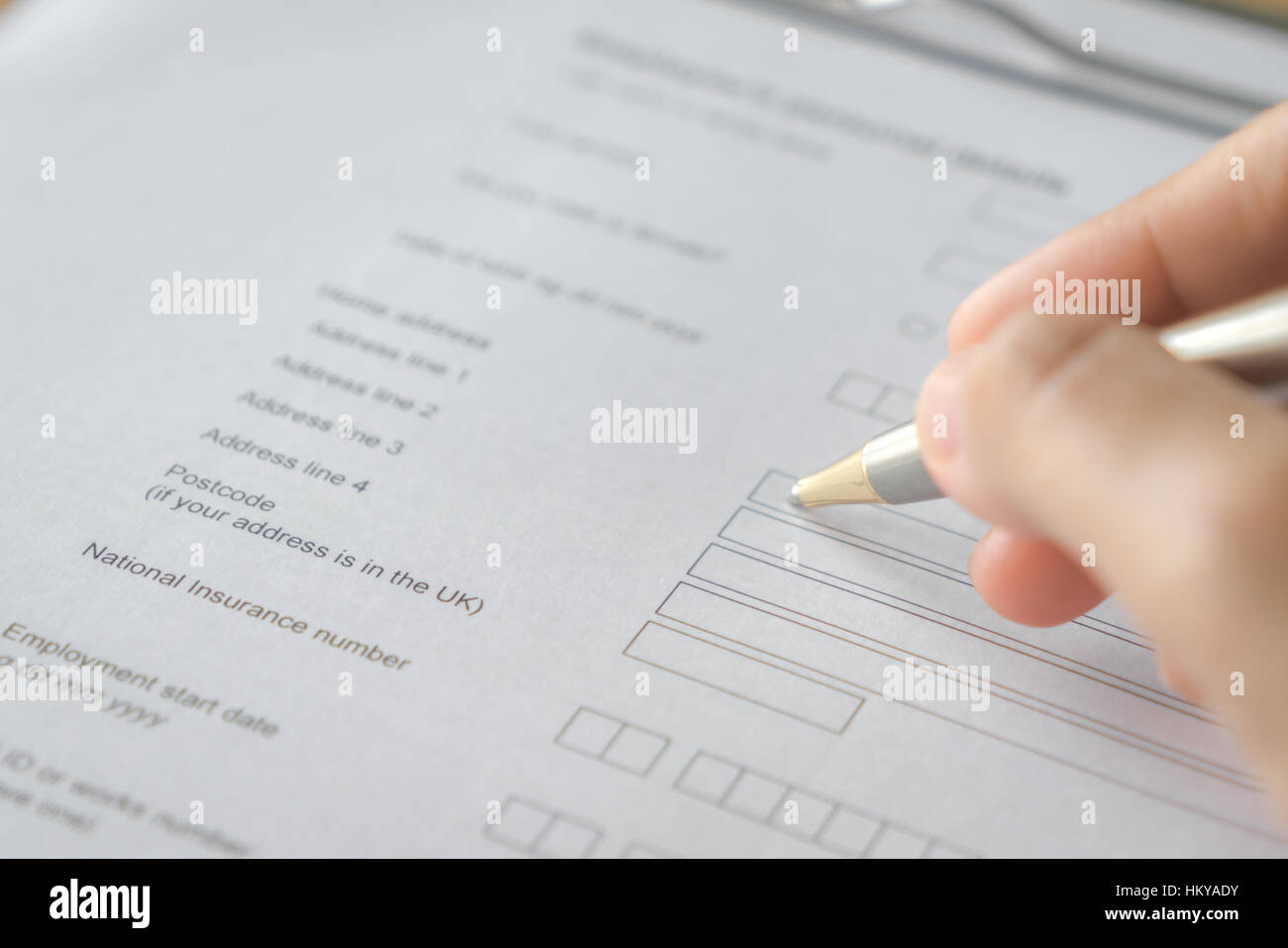Hand with pen over application form Stock Photo - Alamy