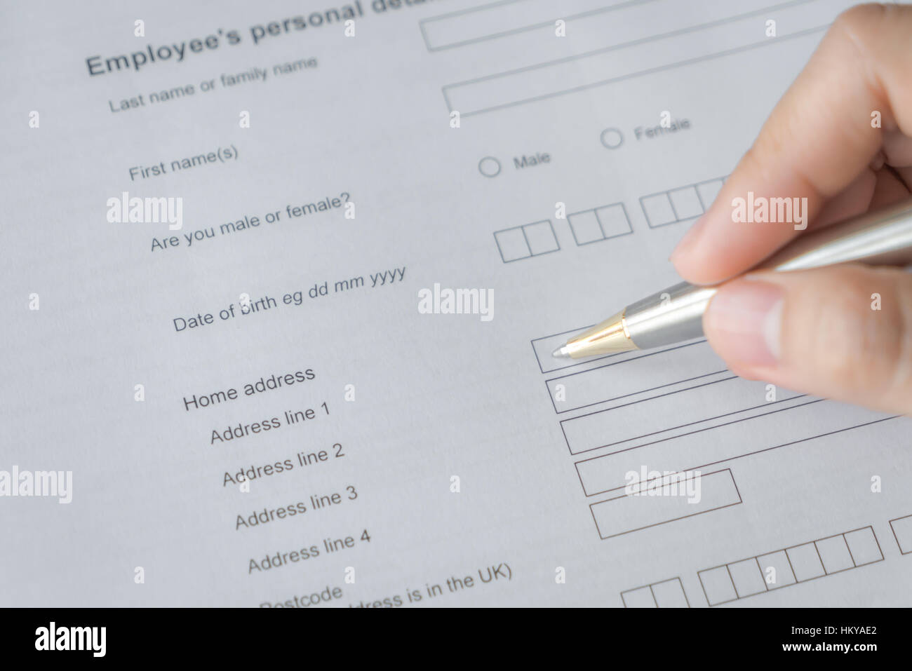 Hand with pen over application form Stock Photo - Alamy