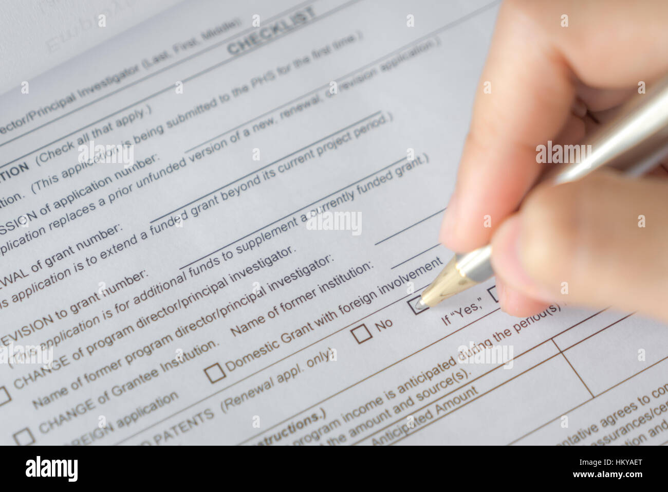 Hand with pen over application form Stock Photo - Alamy