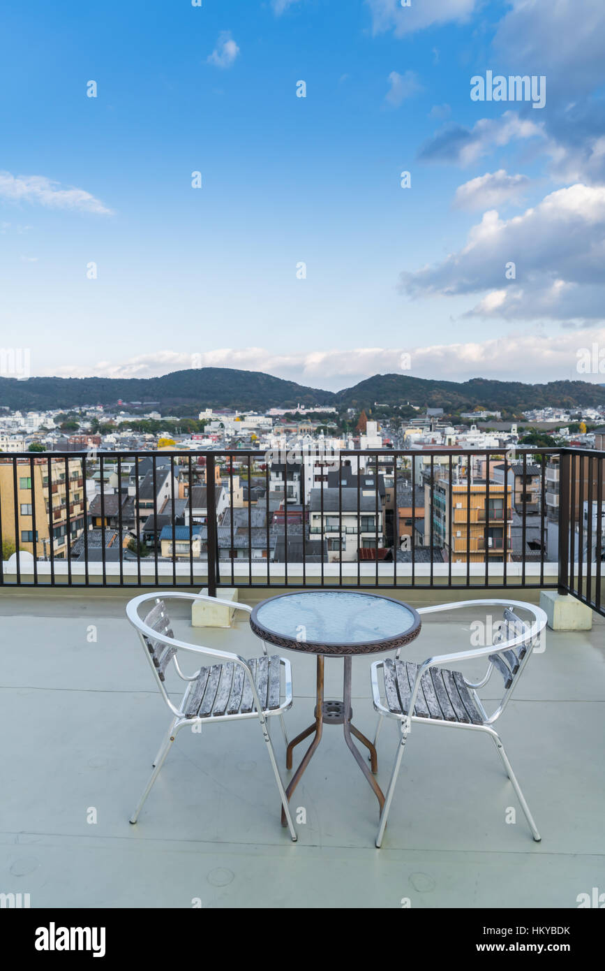Table and chairs on roof top terrace exterior Stock Photo - Alamy