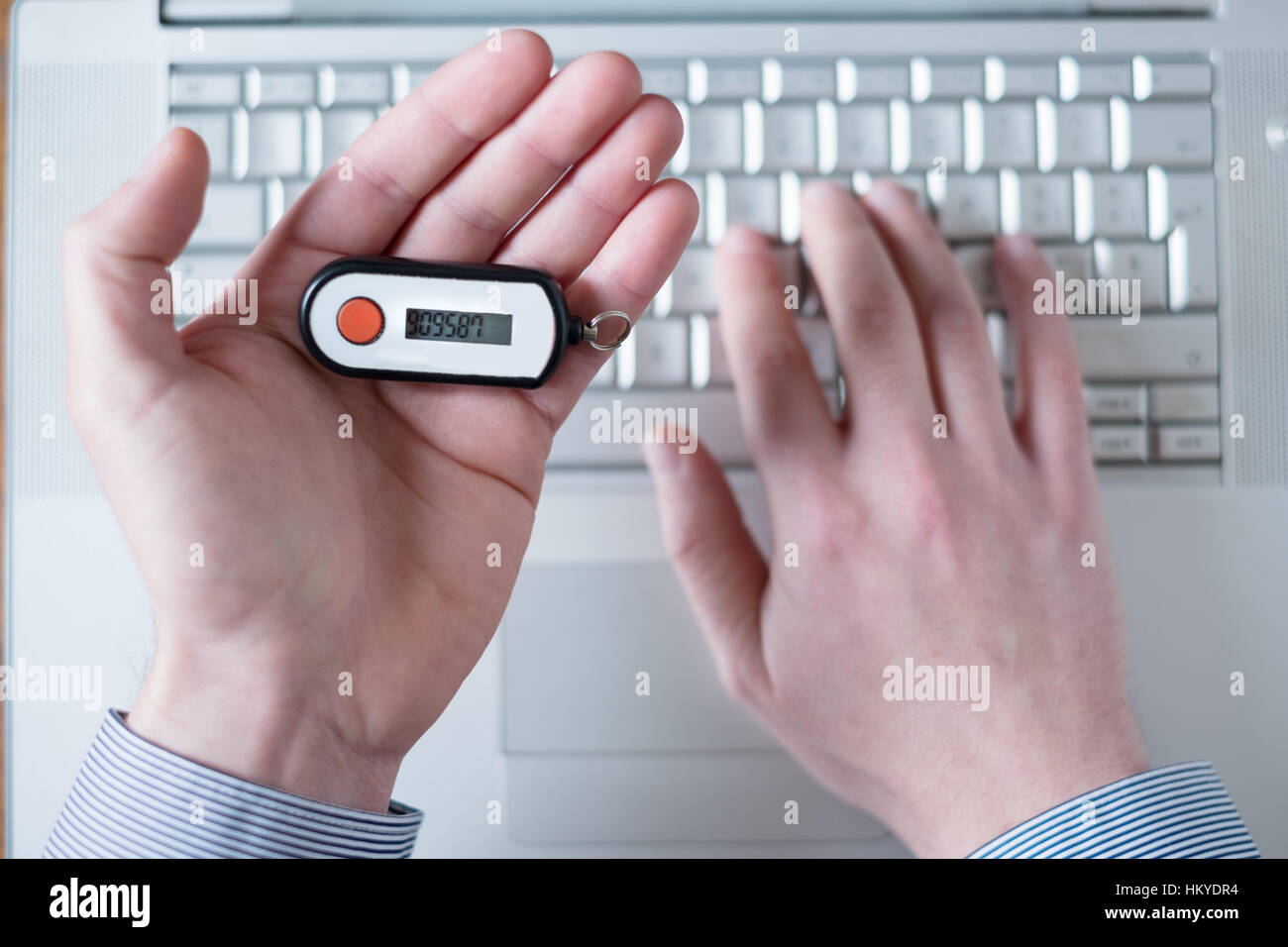 Hand of a person using a security token when using internet banking ...