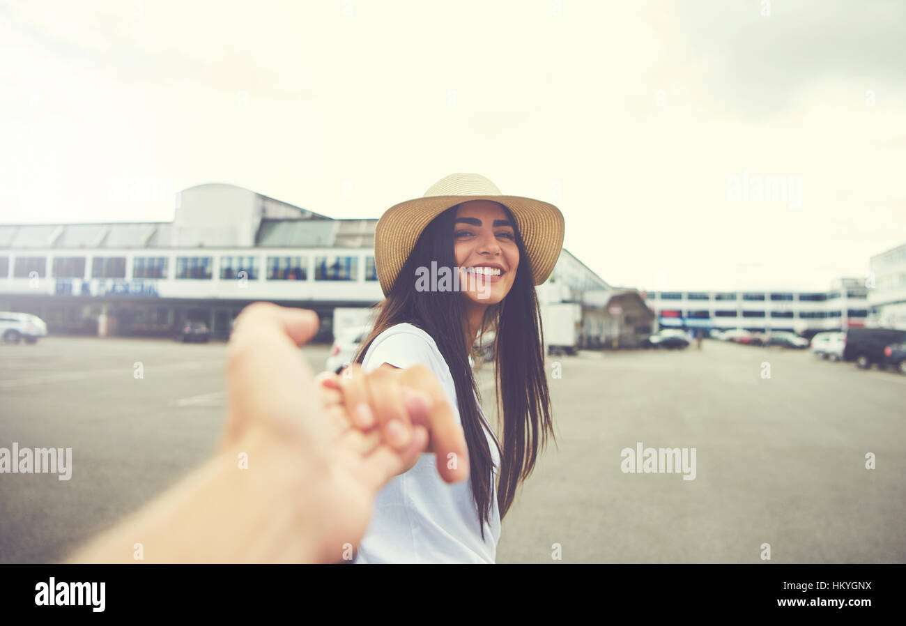 Woman with long hair and hand outstretched towards camera smiles while ...
